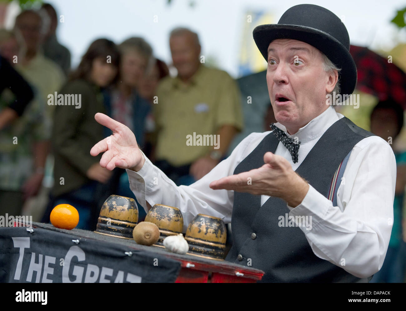Street magician Brando from Argentinia performs a magic trick at the ...
