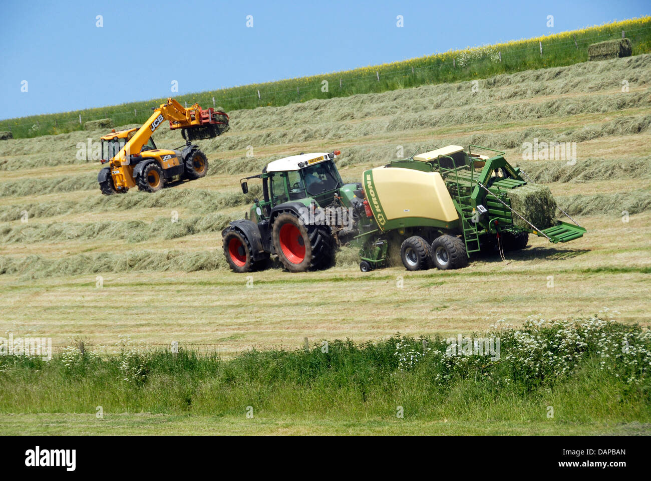 Tractor with baler making hay bales for silage, Sussex, England UK ...