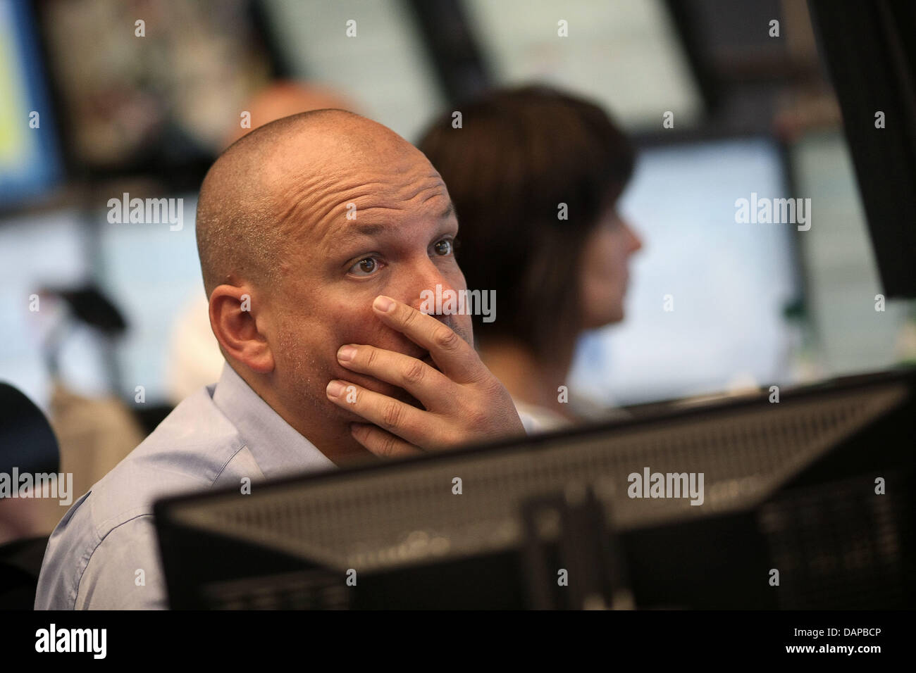 A trader looks to the German DAX stock index at the stock exchange in ...