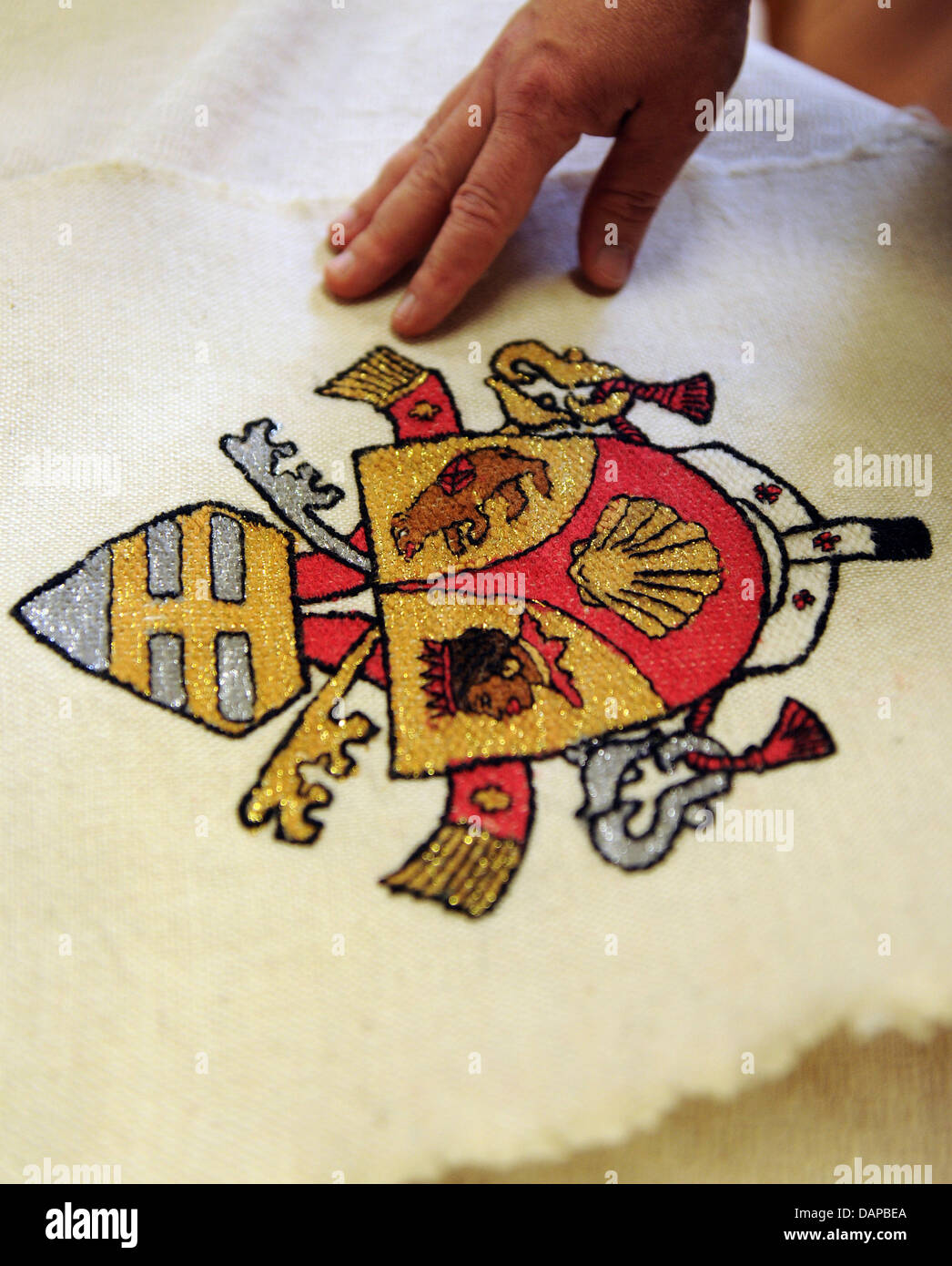 A staff member checks a crest cloth of the chair cloths at the hand ...