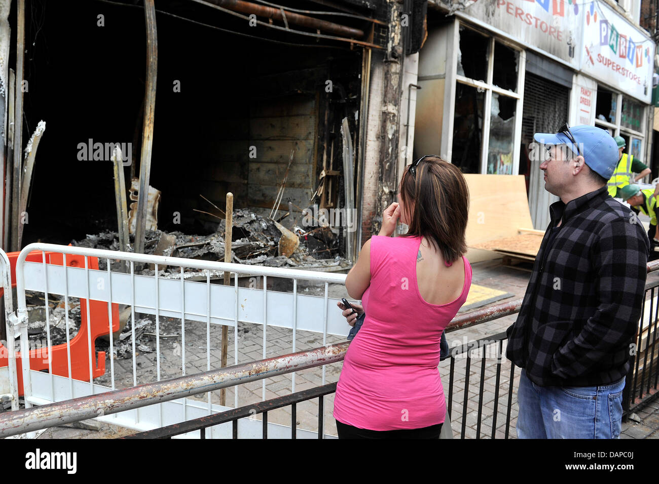 People look at a burnt out shop after riots in Clapham, London, Great ...