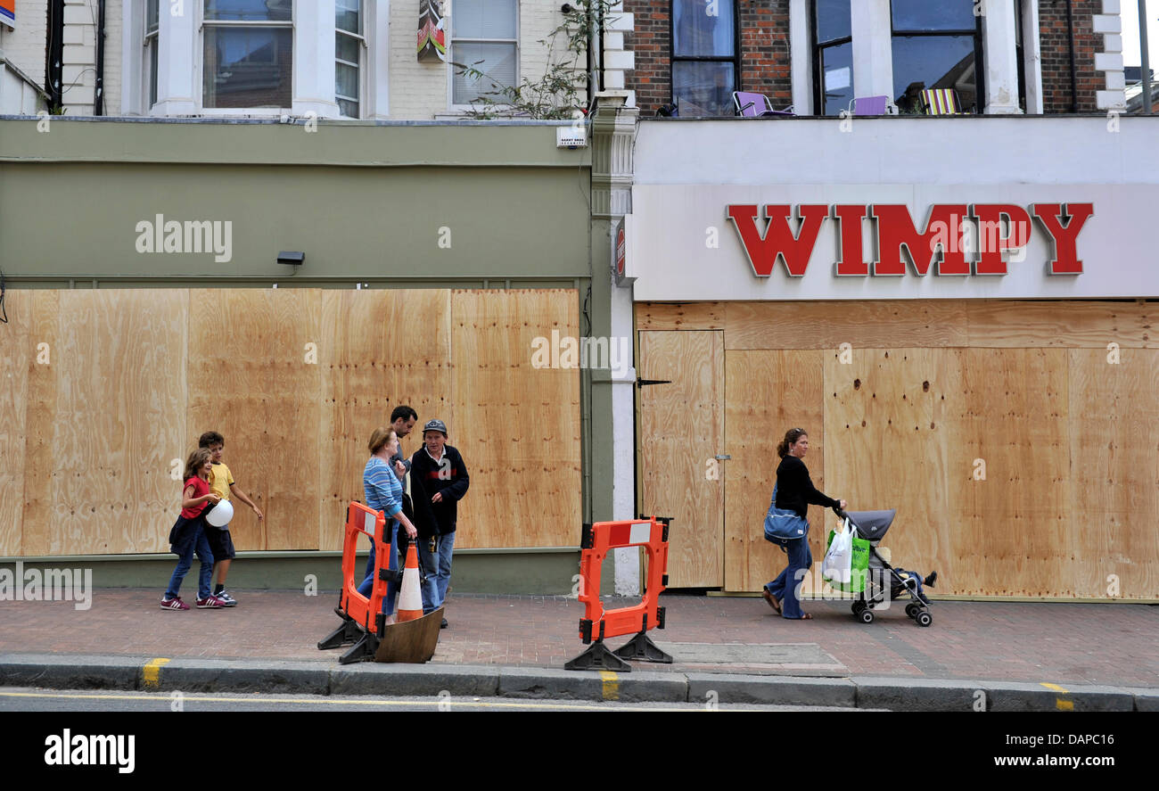 The windows of a shop are covered with wooden planks after riots in ...