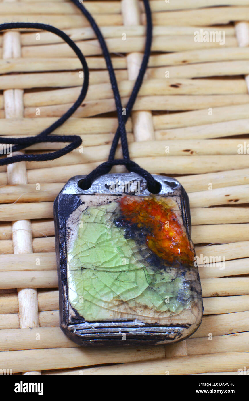 silver clay handmade amulet green and orange Stock Photo - Alamy