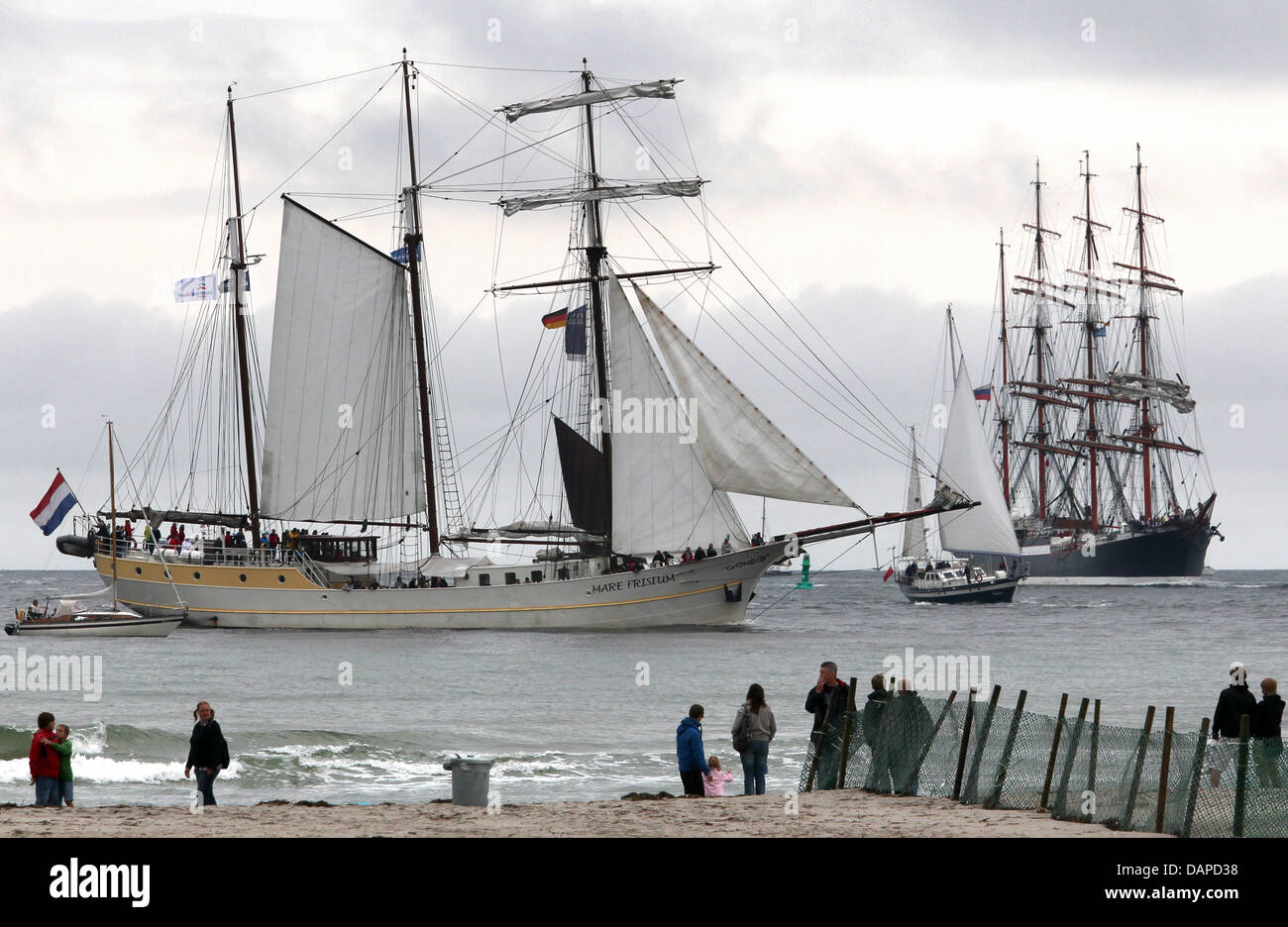 Spectators follow the return of tradition sail boats from an trip to ...
