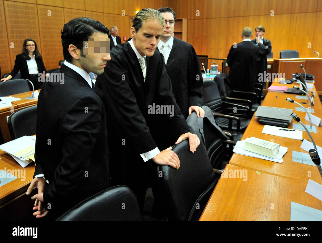 Fraz M. (2 from L), accused of tax evasion, stands next to his lawyer ...