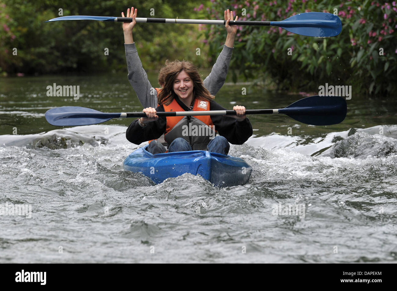 Two young canoers cheer as they paddle through the wild currents of the ...