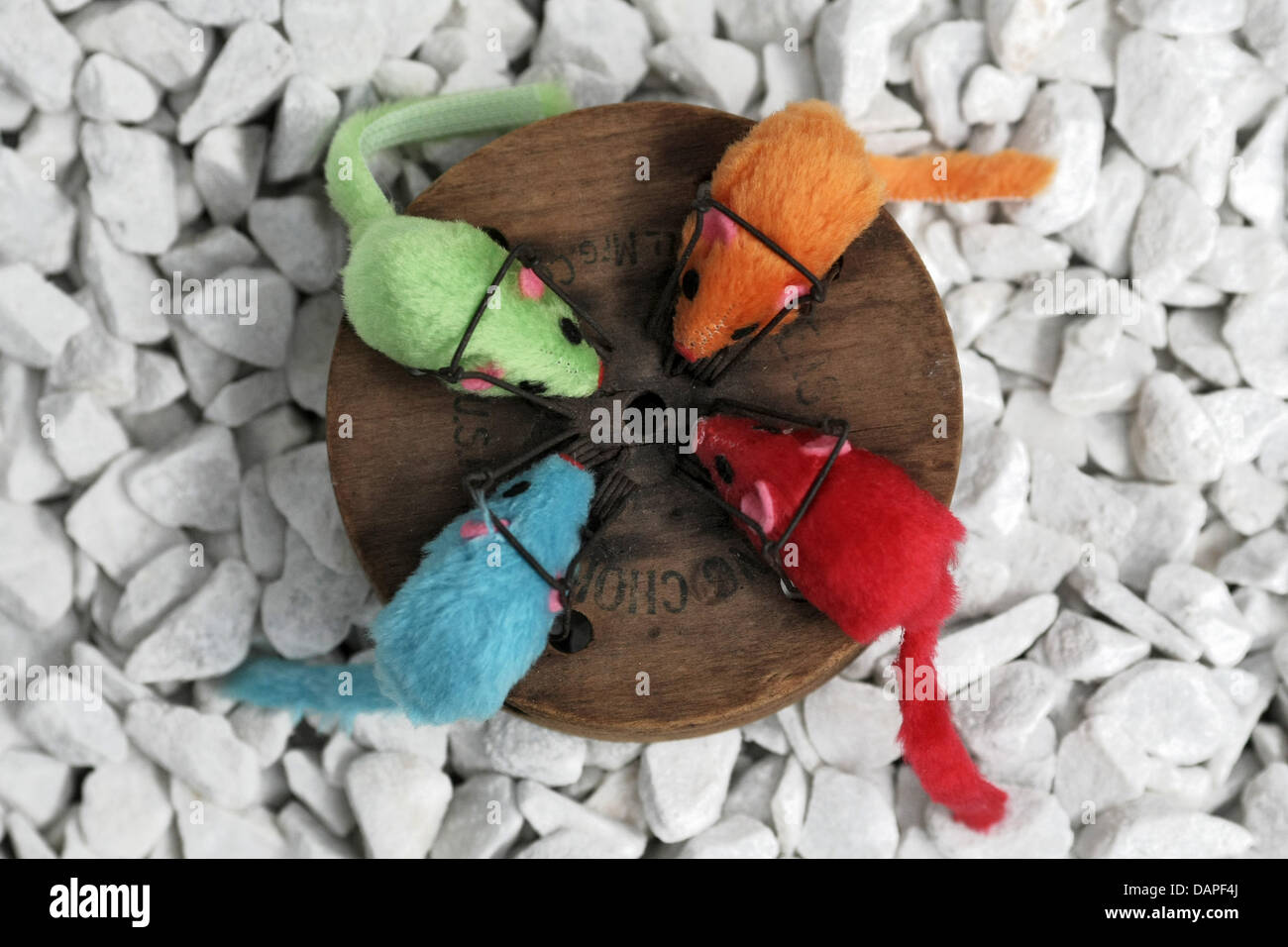 Four coloured toy mice sit inside an US mouse trap from around 1900 at ...