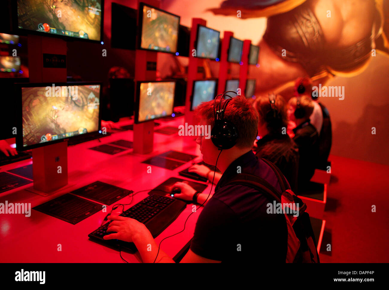 Computer gamers sit in front of screens at the Gamescom fair in Cologne ...