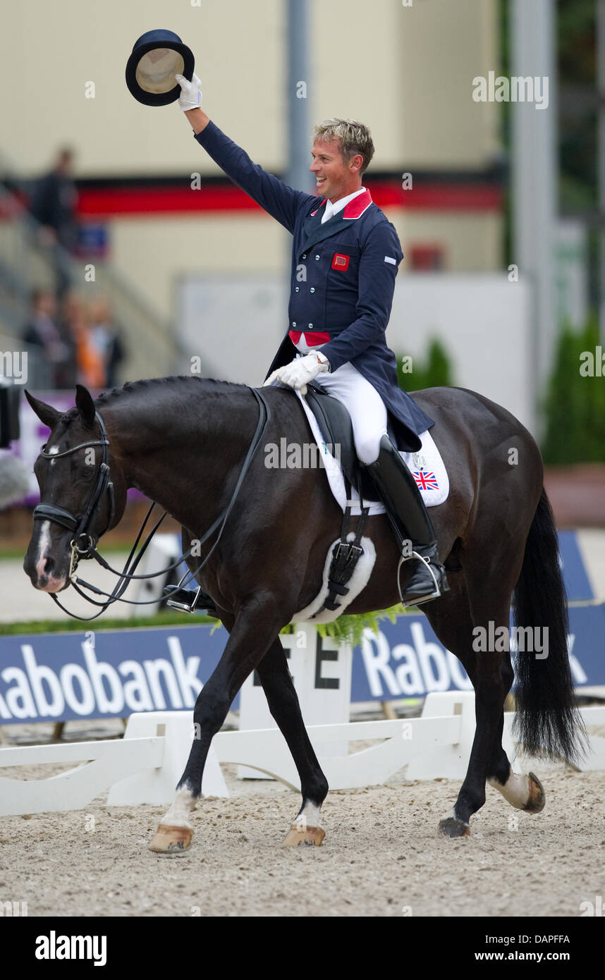 British dressage rider Carl Hester waves as he rides his horse Uthopia ...