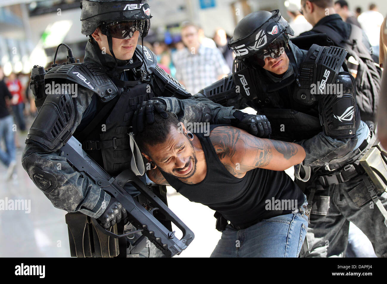 Men dressed as figures of a video game perform a mock arrest with one ...