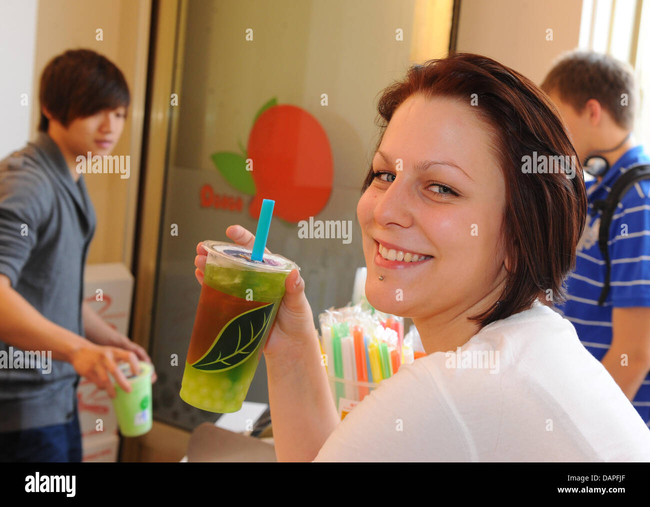 A young woman holds a cup of the latest cult drink Bubble Tea or Bubble ...