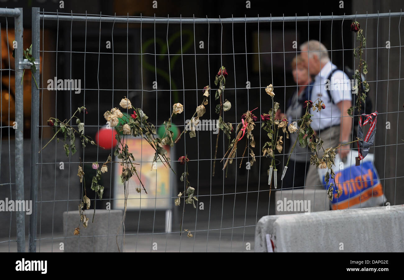 A couple walks past the crime site of the attacks in Oslo, Norway, 19 ...