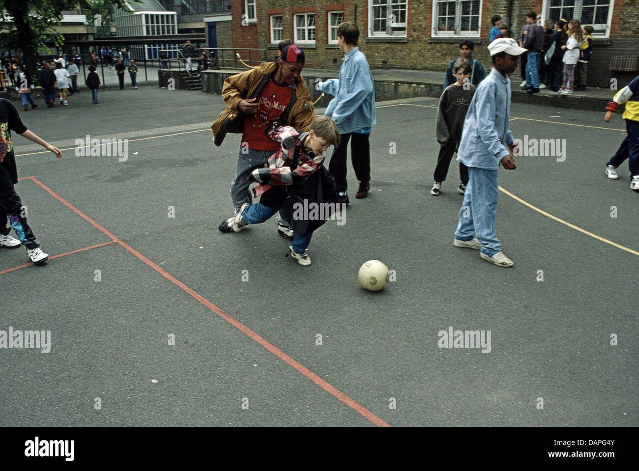 boys playing football in school playground Stock Photo - Alamy
