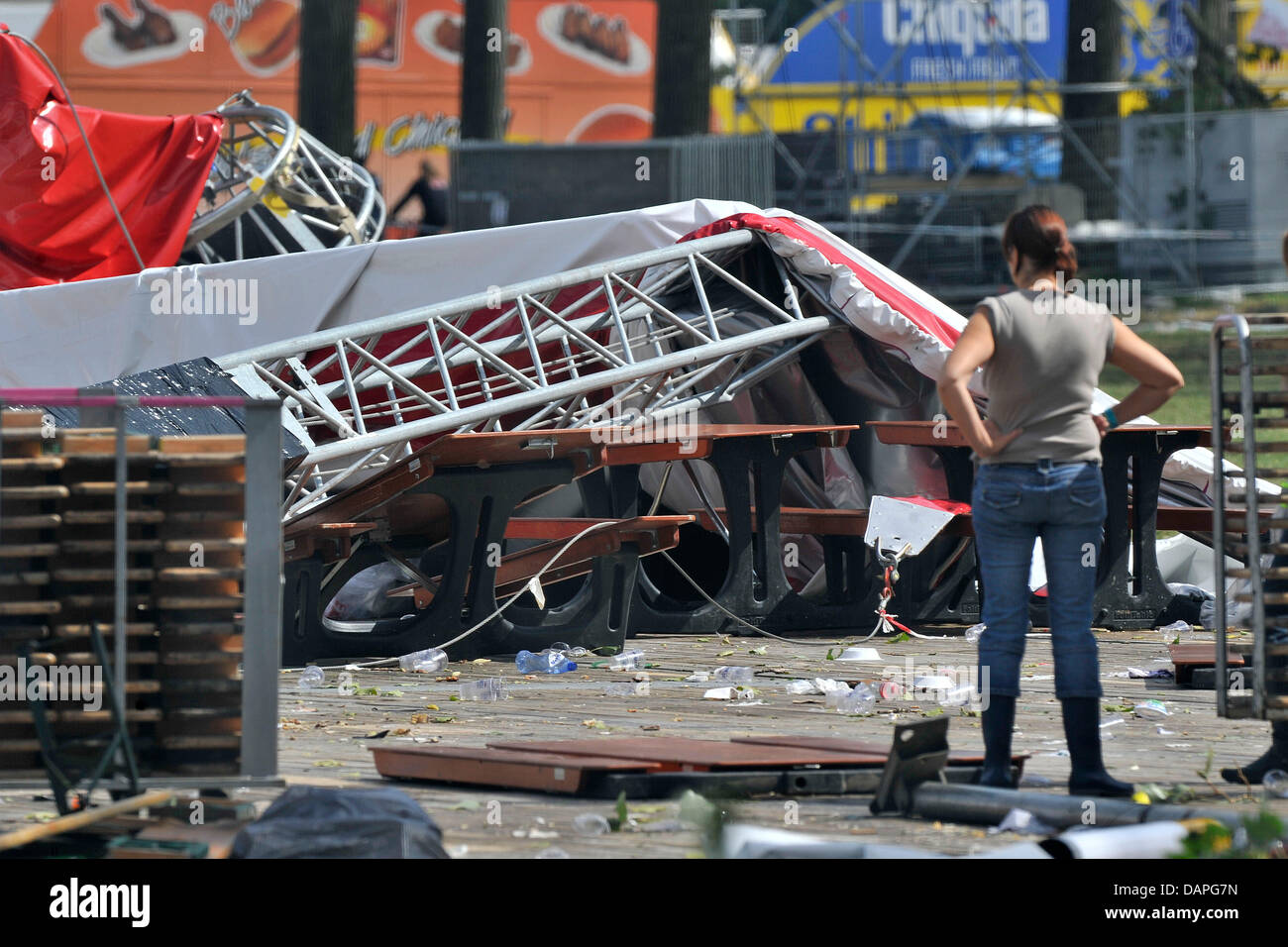 A woman stands in front of a destroyed tent at the festival area in ...