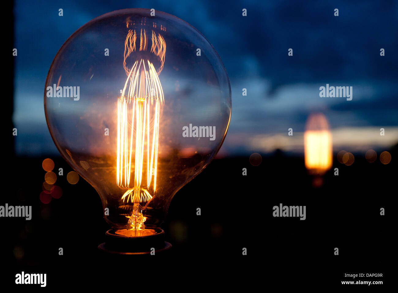 Close up of round bulb with nice filaments, sunset and reflections of ...