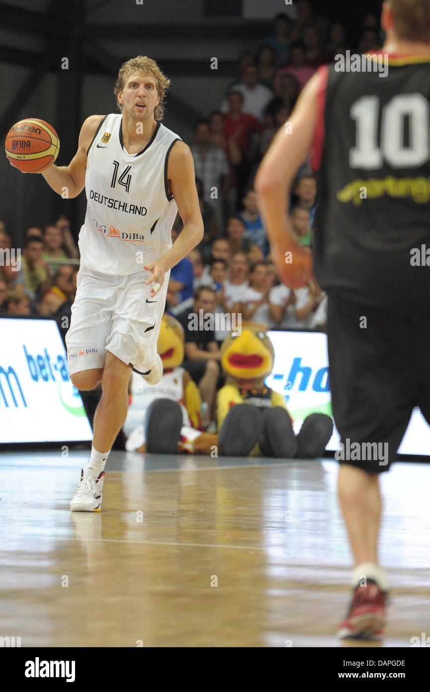 German basketball player Dirk Nowitzki (L) dribbles with the ball as he ...