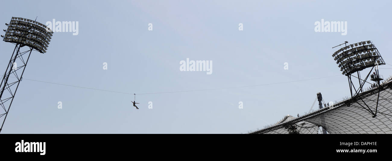 A boy rides on a Flying Fox past the Olympic Tower during an outdoor ...