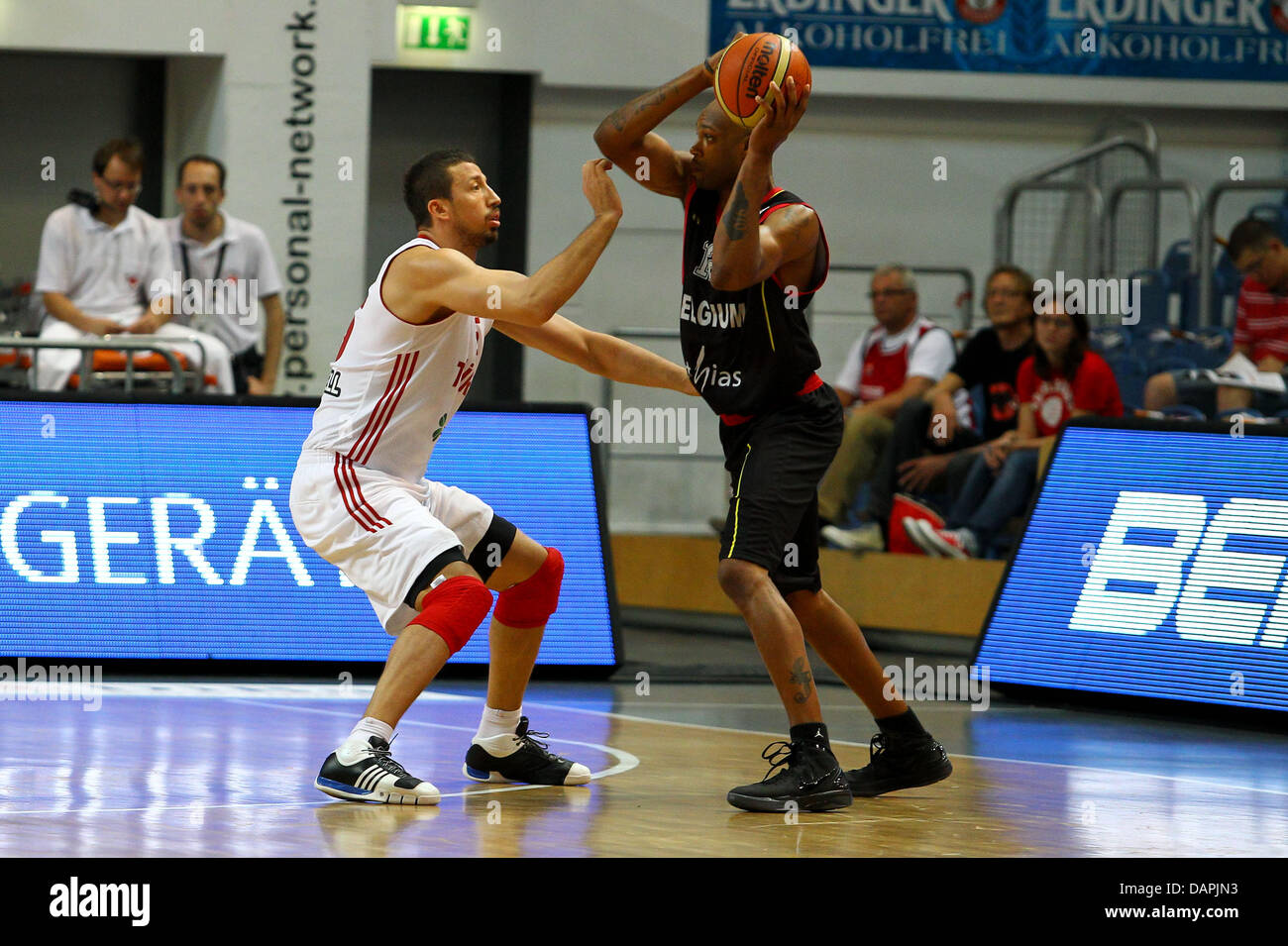 Belgium's national basketball player Marcus Faison (R) tires to go past ...