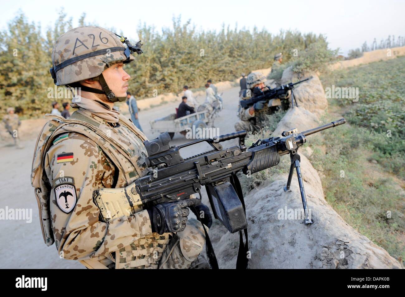 German Armed Forces soldiers hold their weapons at the ready on patrol ...