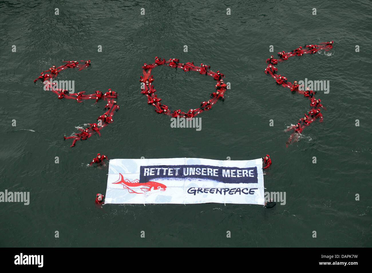 Around 50 Greenpeace activists form the international rescue sign 'SOS ...