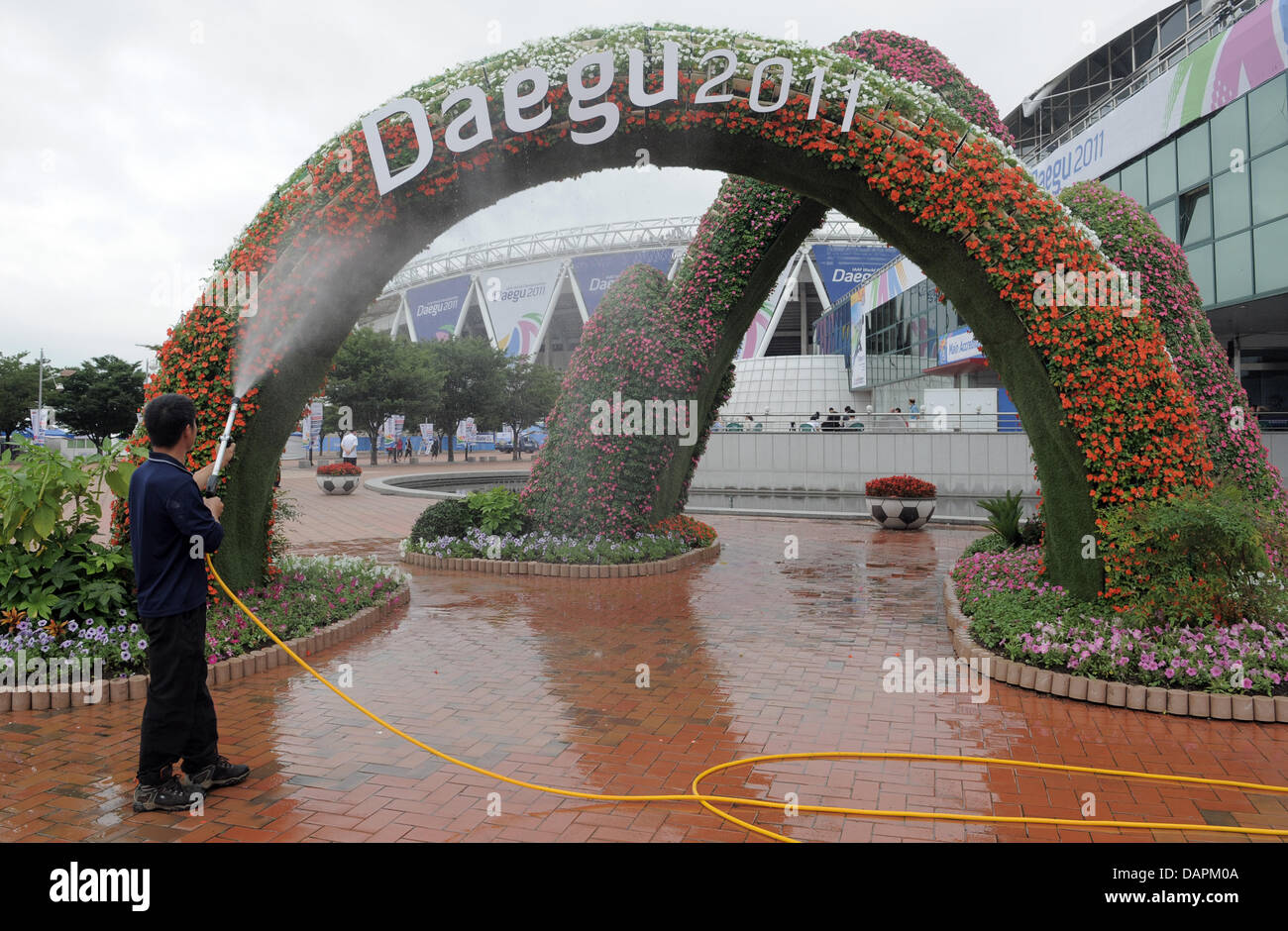 A worker puts the finishing touch around a floral display outside the ...