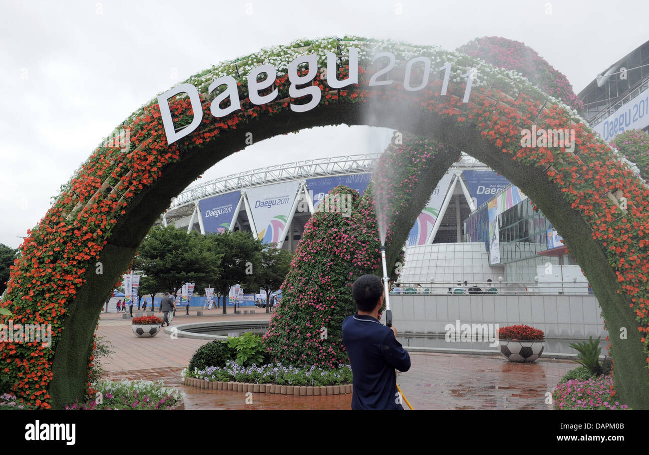 A worker puts the finishing touch around a floral display outside the ...