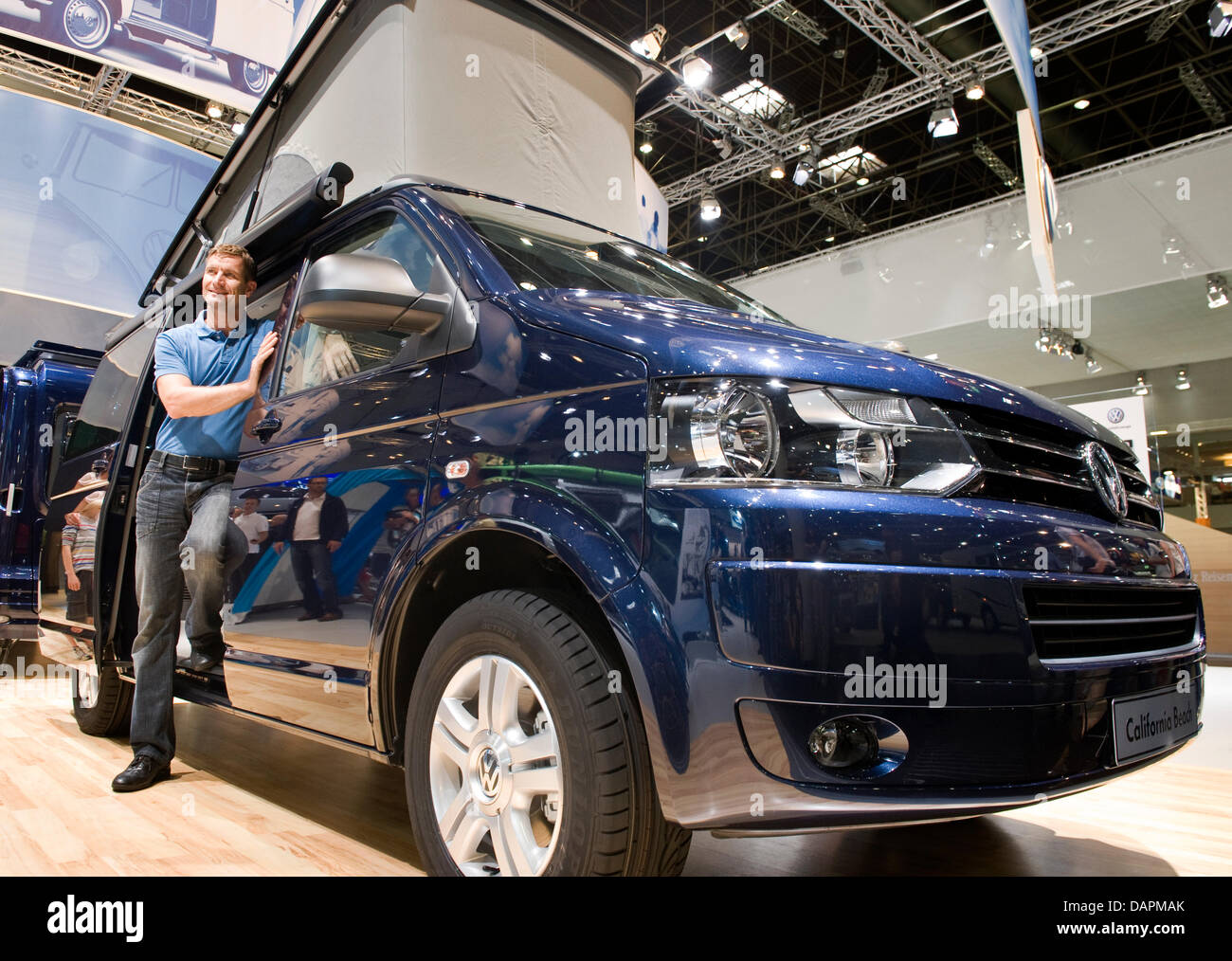 A man poses in front of a Volkswagen T5 caravan at the Caravan Salon ...