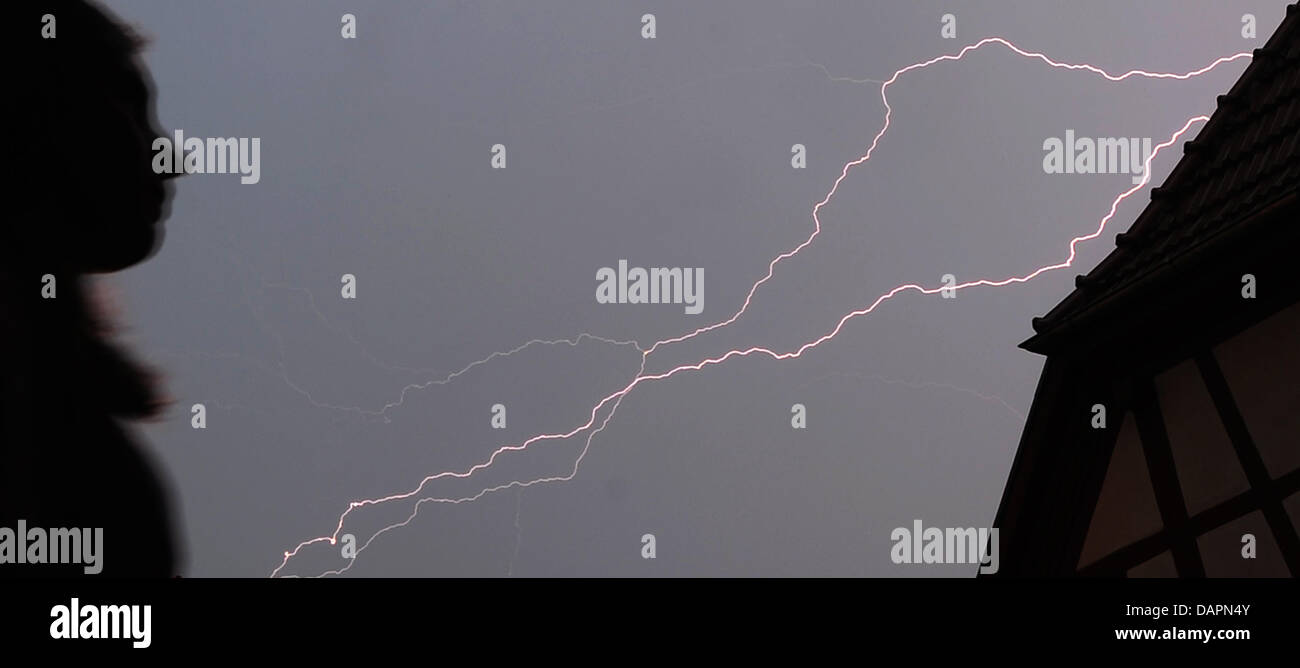 A woman stands as lightning fills the sky behind her in Wackernheim ...