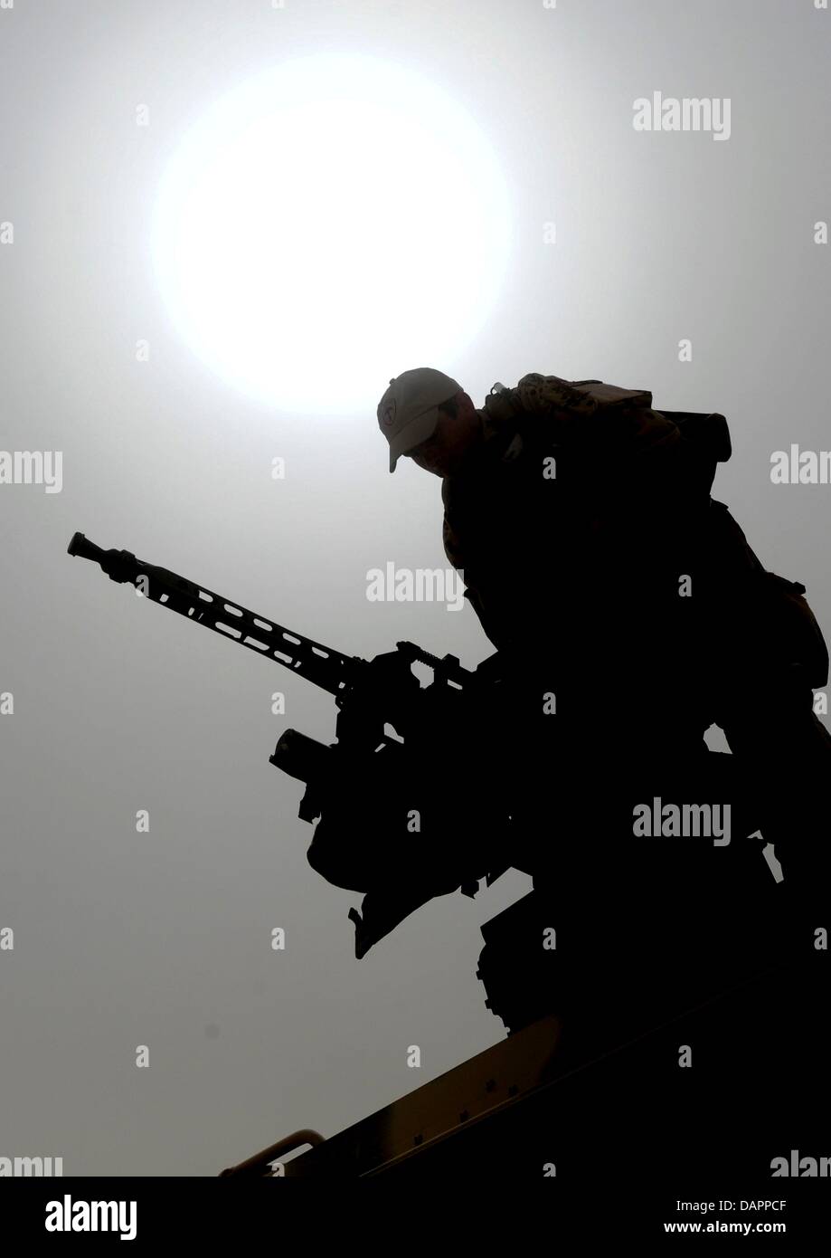 A Bundeswehr soldier works on a machine gun after returning to the camp ...