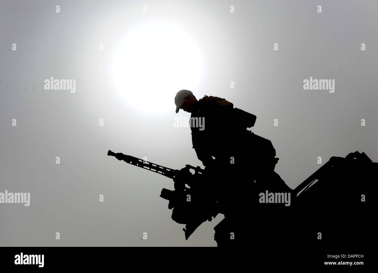 A Bundeswehr soldier works a machine gun after a convoy to an outpost ...