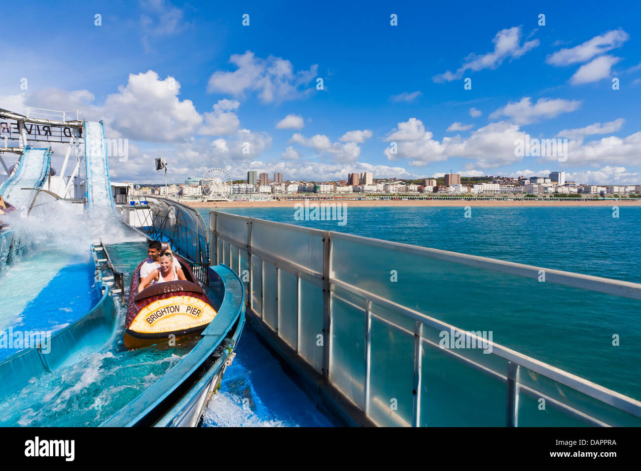 England, Sussex, Brighton, People sitting in water slide at amusement ...