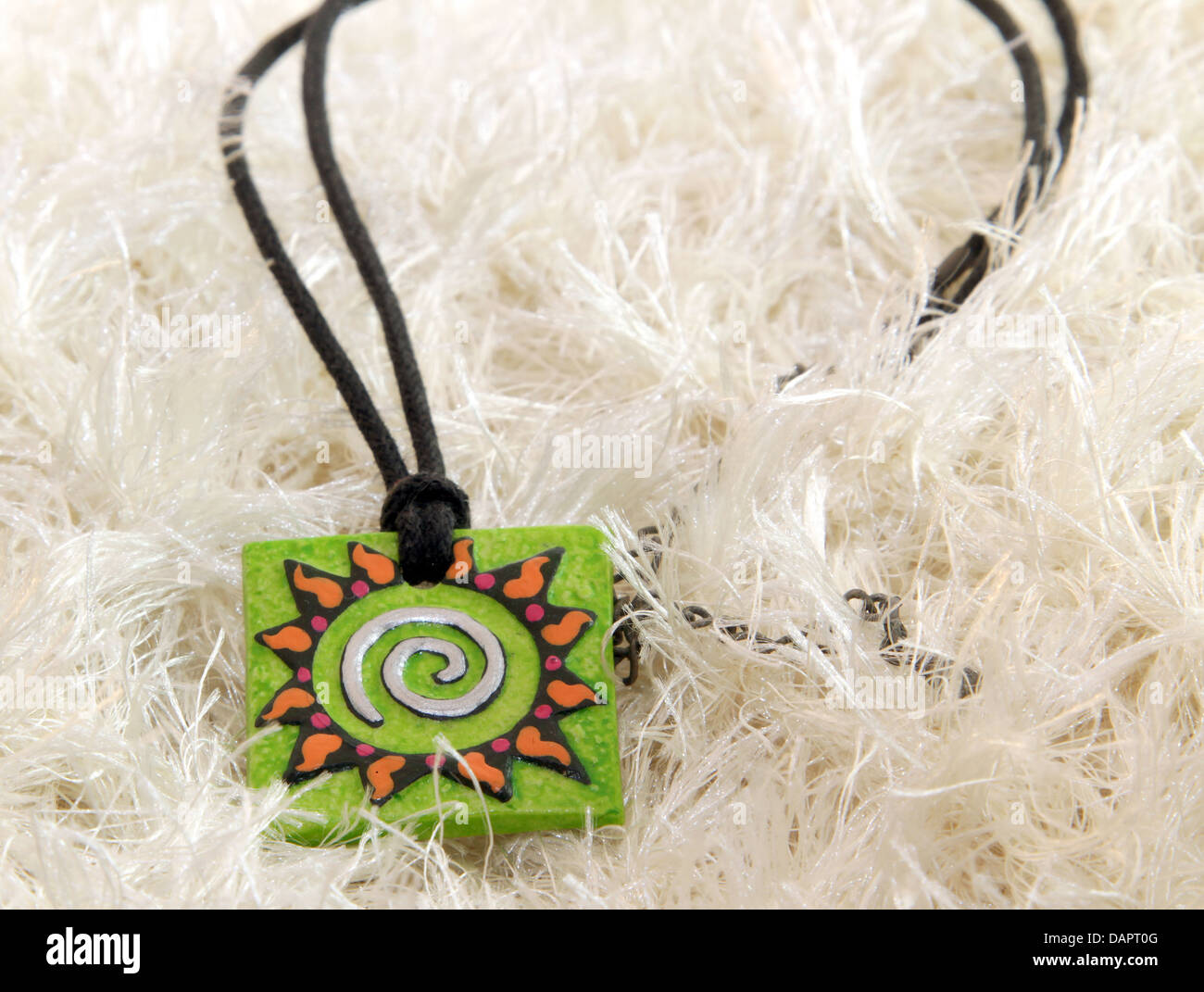 clay handmade green amulet (sun) on a knitted background Stock Photo ...
