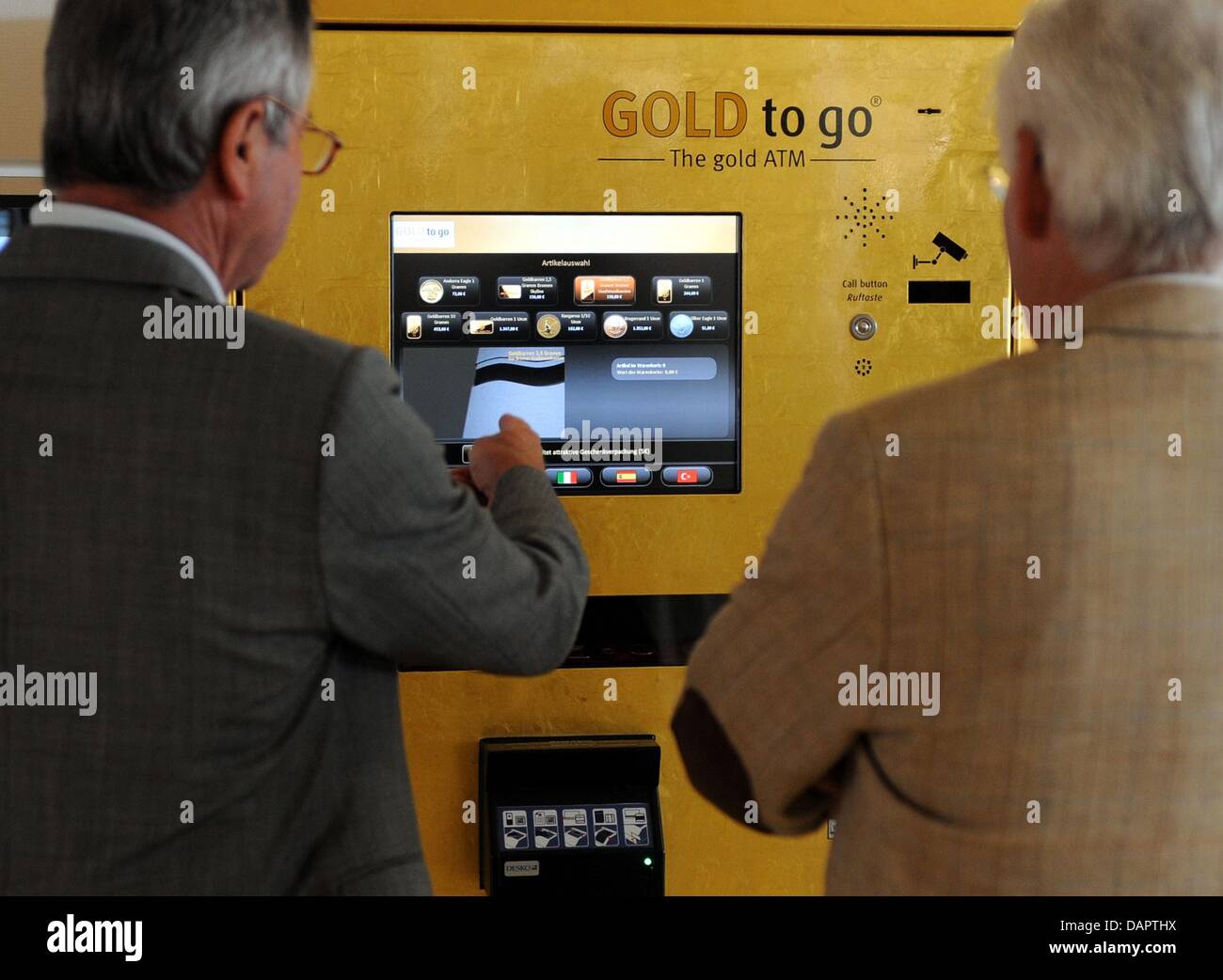 Travelers look at the recently installed 'Gold to go' vending machine ...