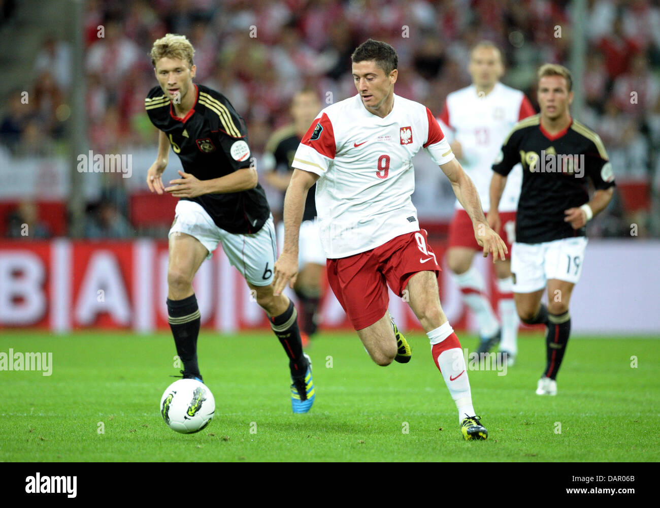 Poland's Robert Lewandowski (C) and Germany's Simon Rolfes (L) fight ...