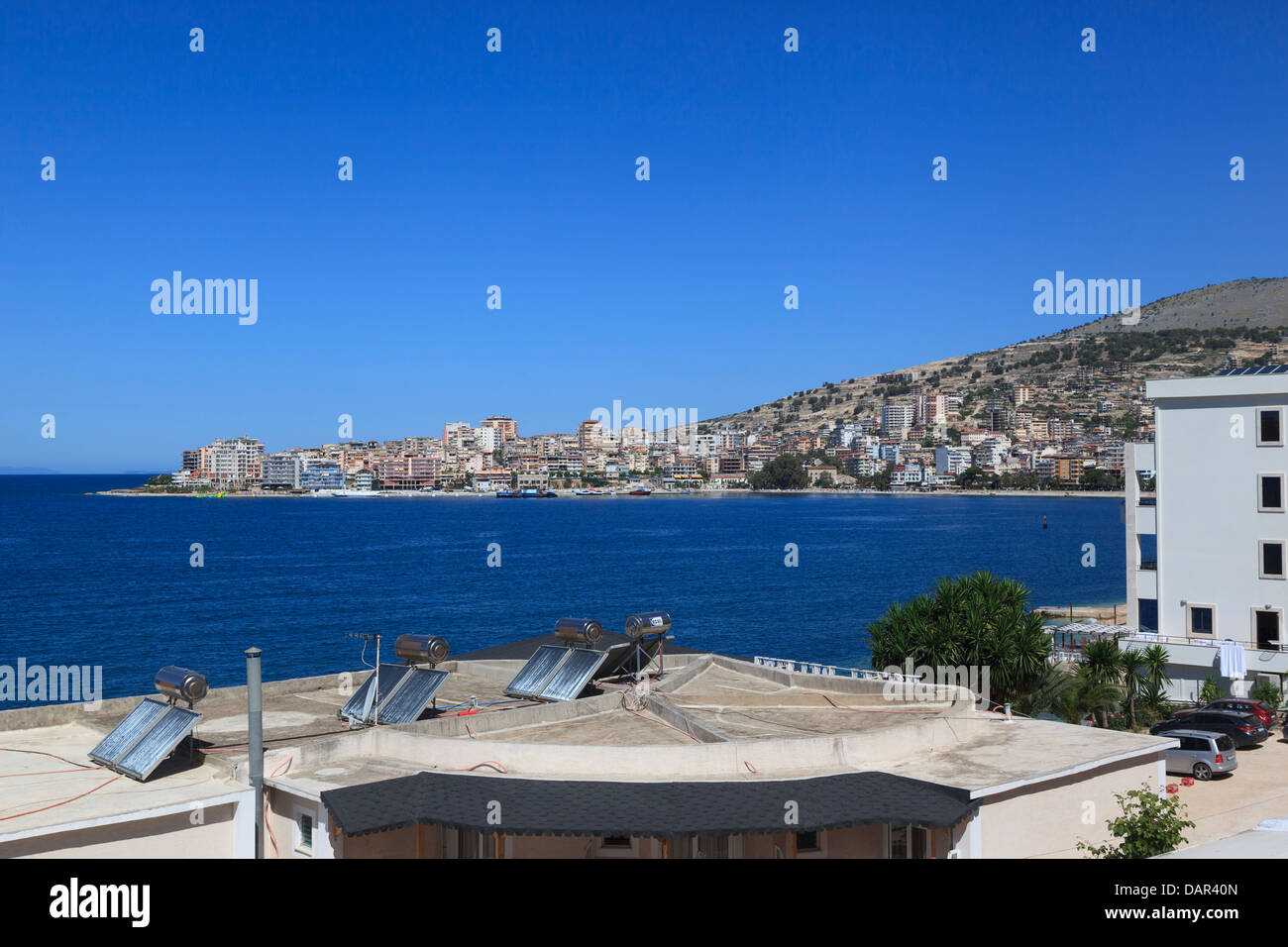The seafront in Saranda, Alabania with solar panels on a roof in the ...