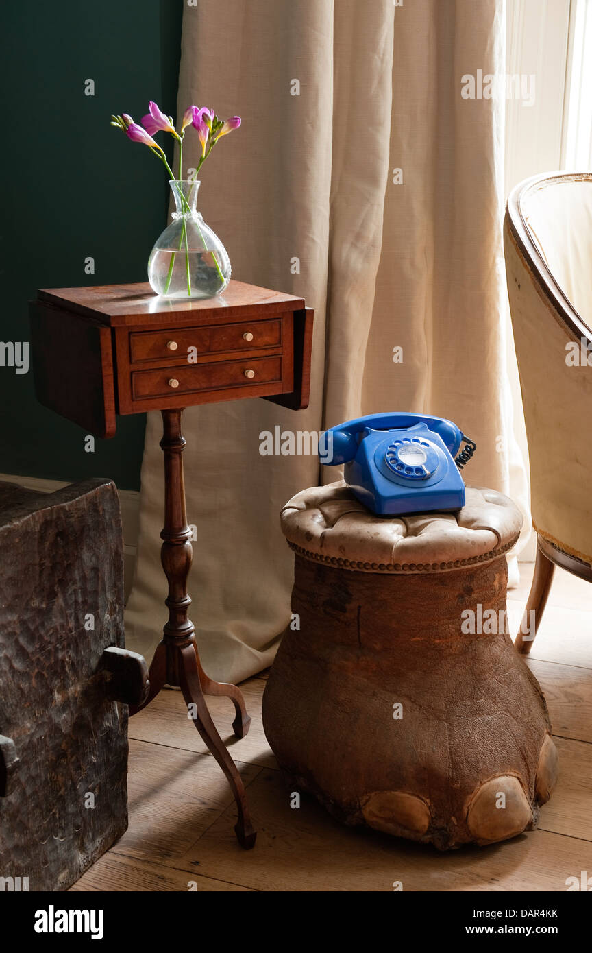 Rotary dial telephone on elephant foot stool in Gloucestershire country ...
