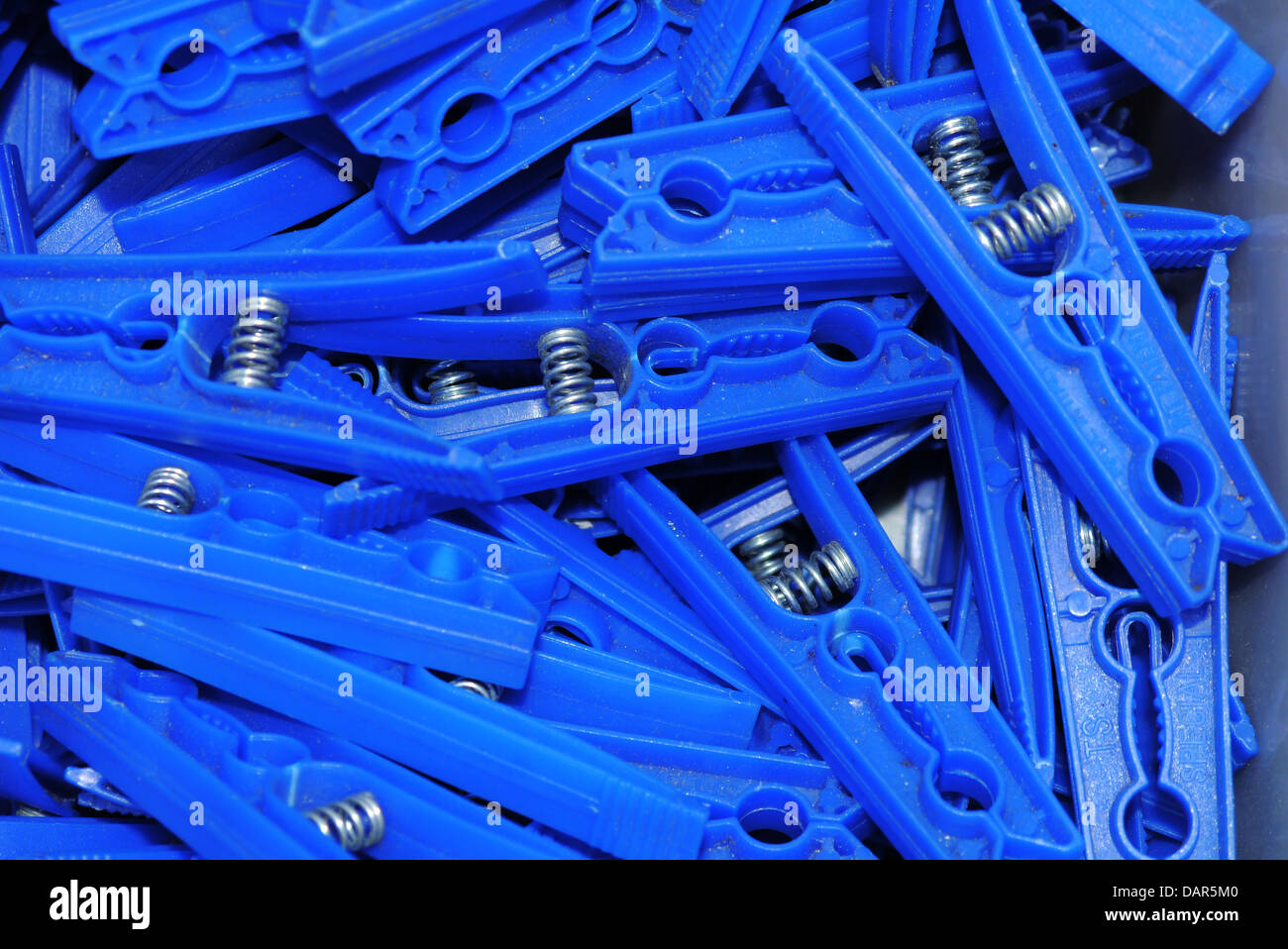 A close-up image of a blue spring-loaded clothes peg, commonly used for ...