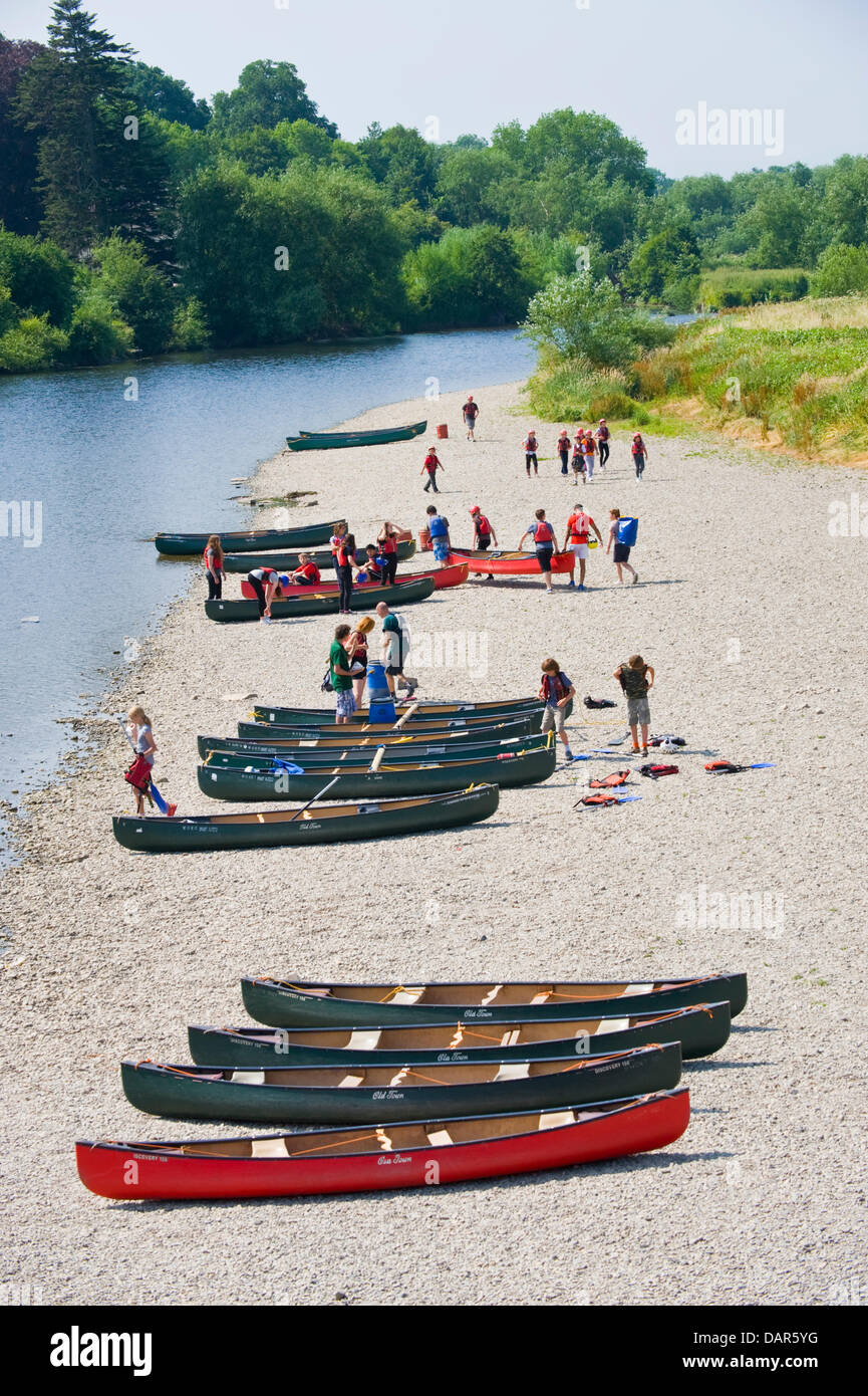 Groups of children under instruction for canoeing in open canoes on the ...