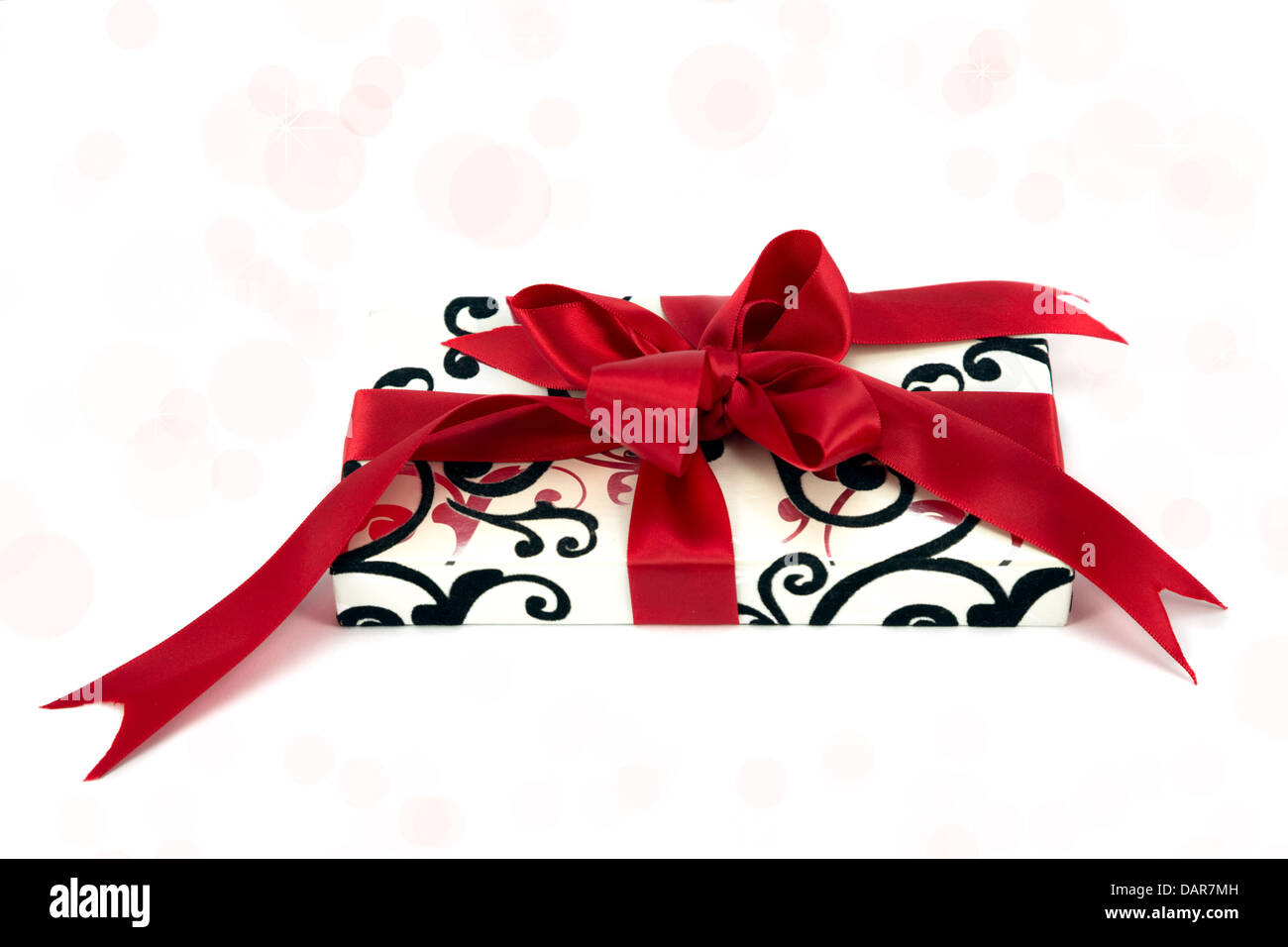 Gift wrapped with a red ribbon Stock Photo - Alamy