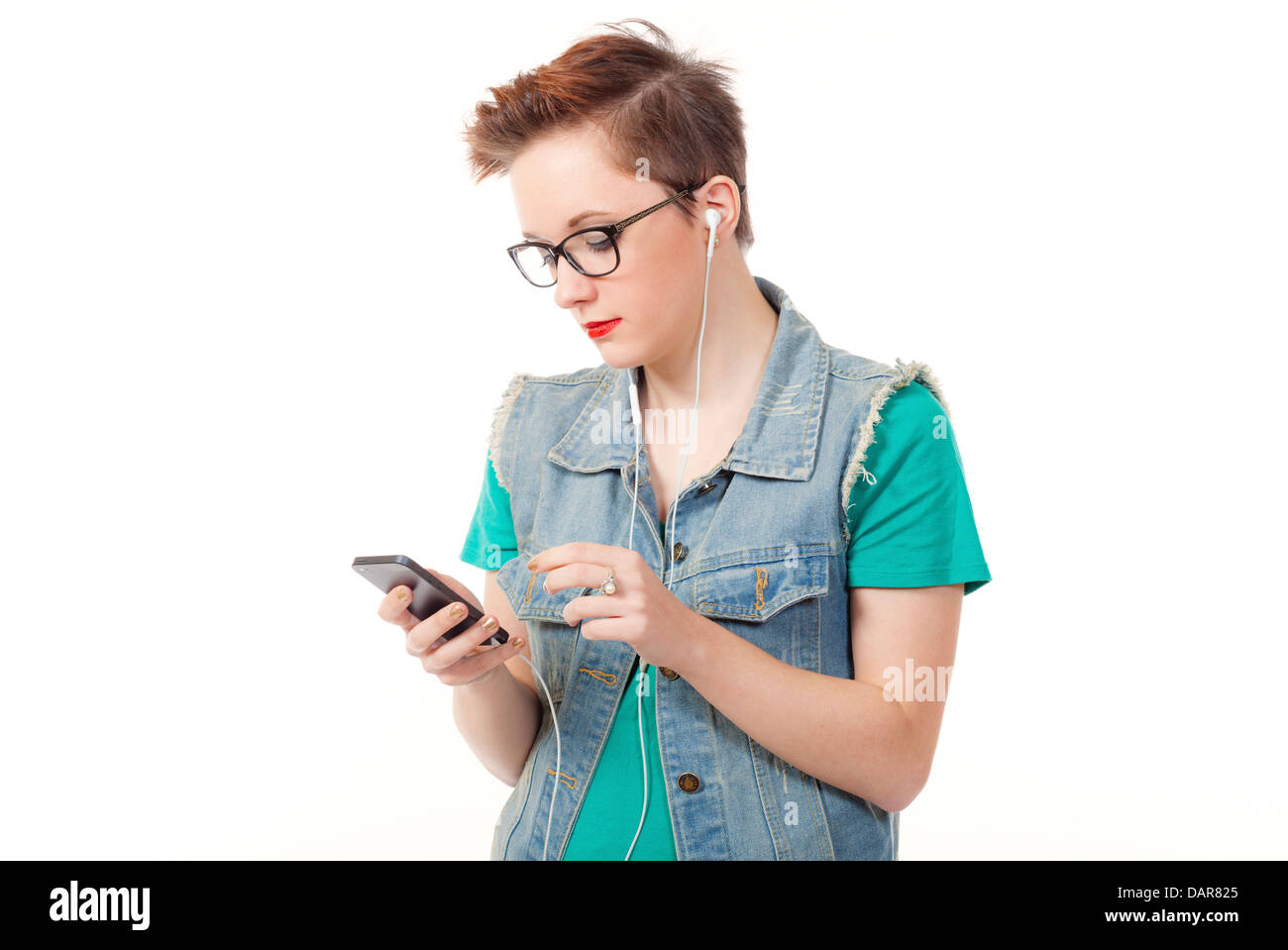 Teenage girl, dressed casually, poses holding an iphone listening to ...