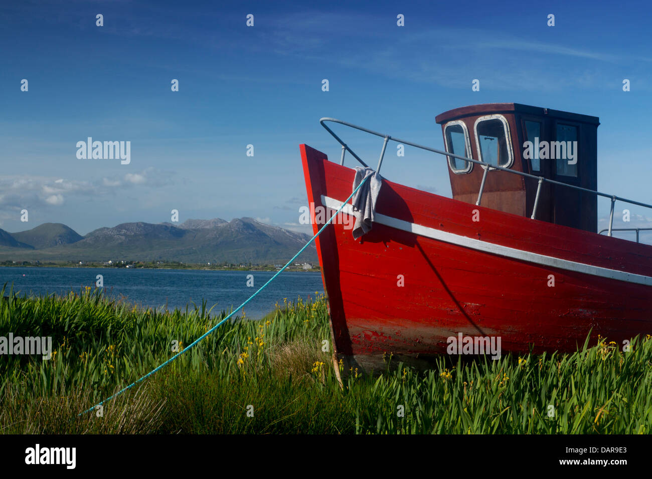 Red fishing boat on bank of estuary Roundstone Connemara Some of the ...