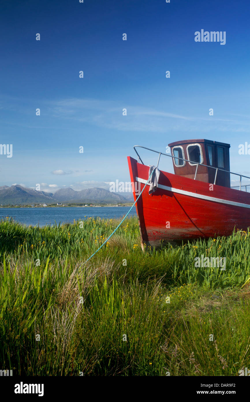 Red fishing boat on bank of estuary Roundstone Connemara Some of the ...
