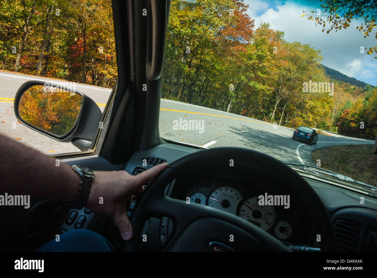 The beautiful colors of Fall leaves line the winding road on an Autumn ...