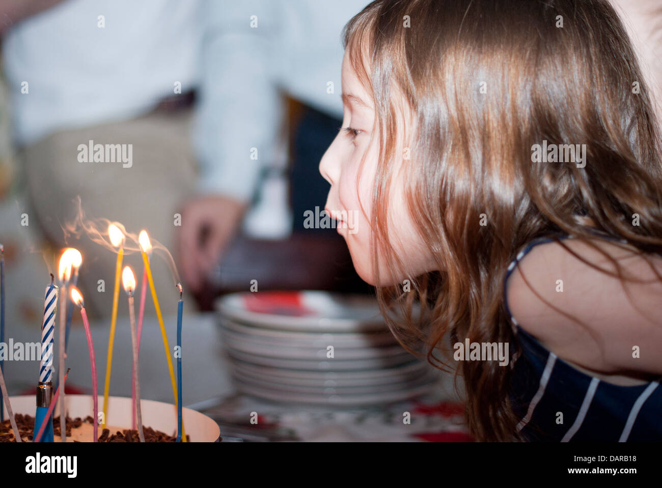 Girl blowing candles out on a birthday cake Stock Photo - Alamy