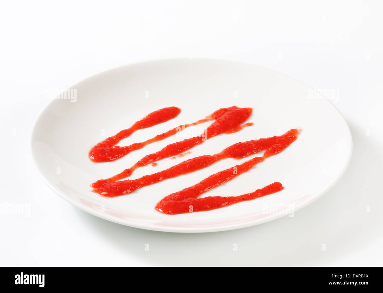 Strawberry drizzle sauce on plate Stock Photo - Alamy