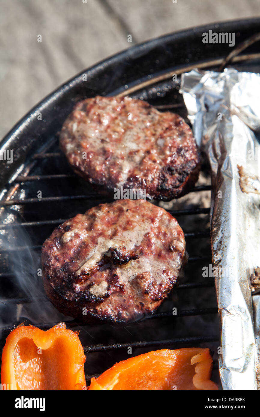 Burgers being cooked on a barbecue Stock Photo - Alamy