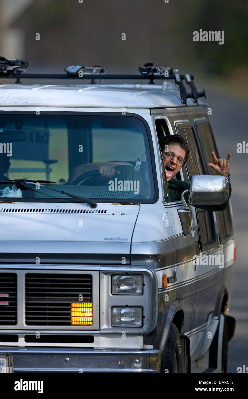 Young male gestures out of a van while driving Stock Photo - Alamy