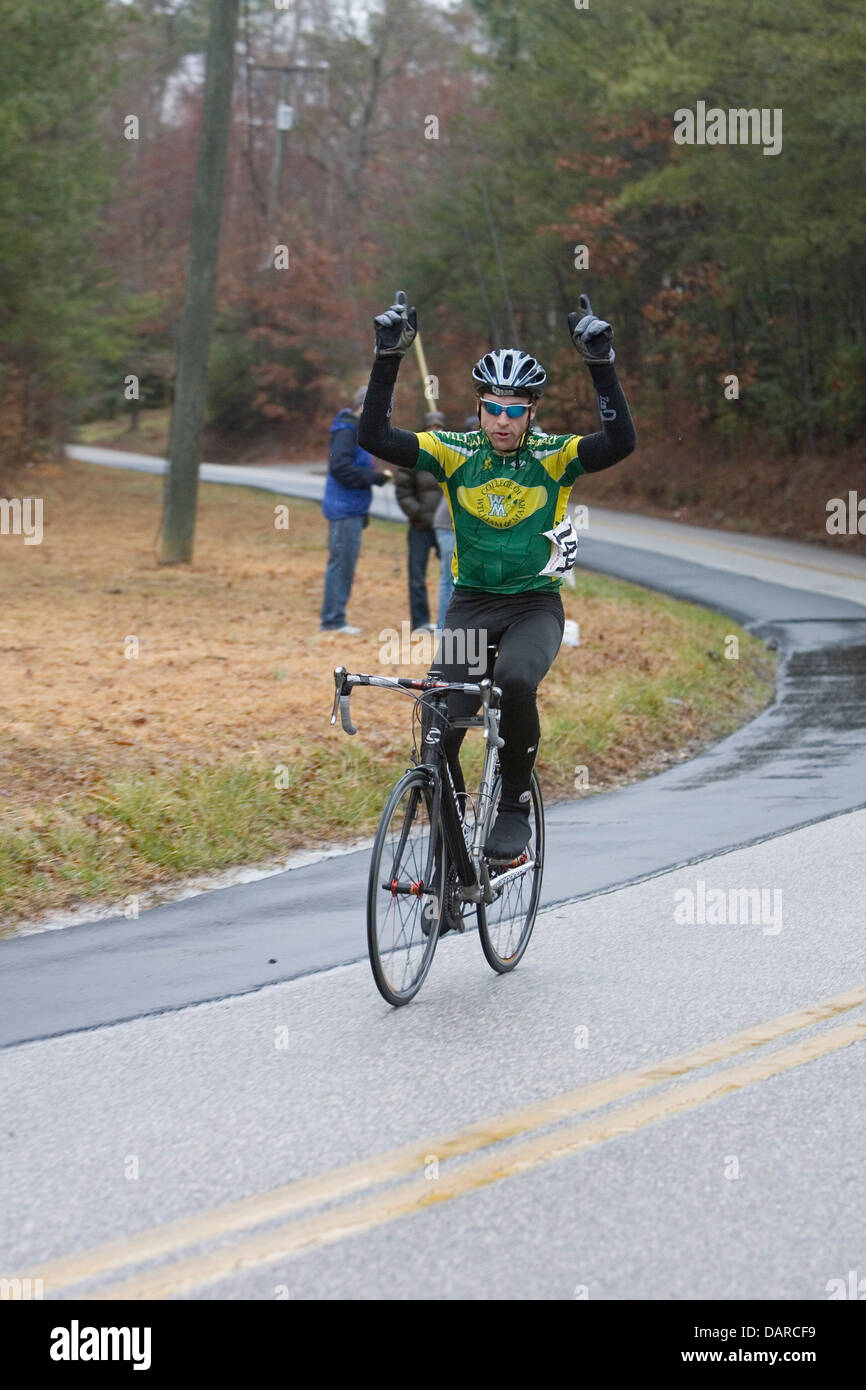 A male cyclist celebrates with arms up after winning a road race Stock ...