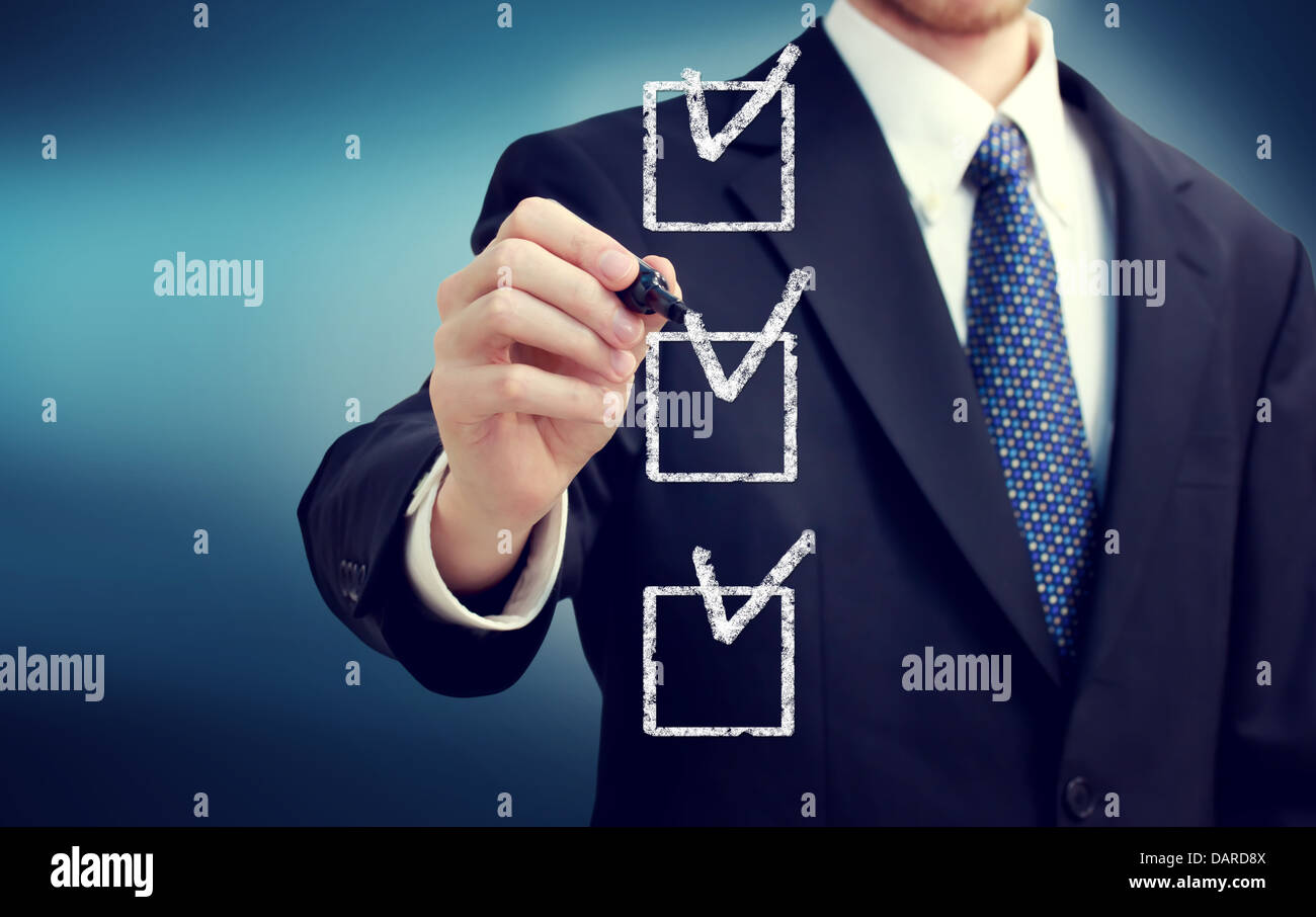 Business man with check boxes over navy blue background Stock Photo - Alamy