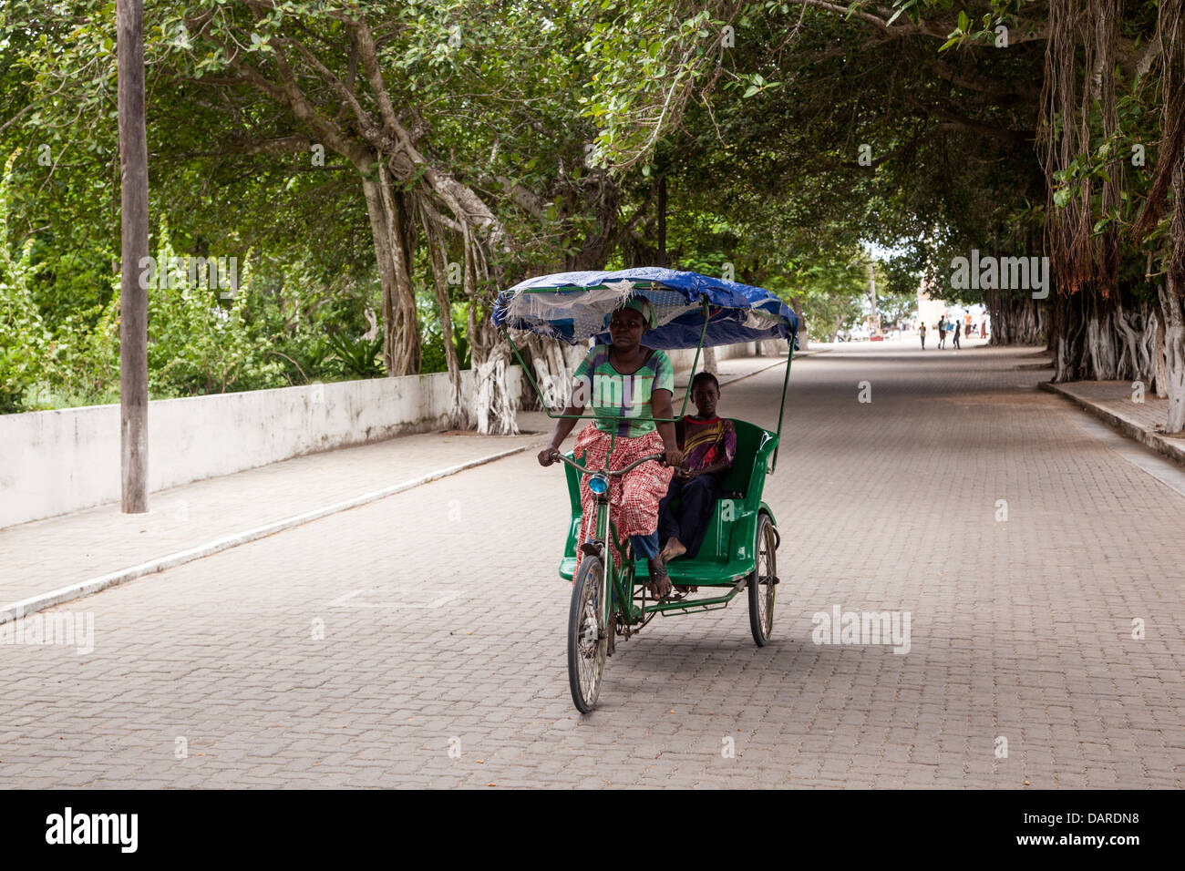 Africa, Mozambique, Mozambique Island. Woman driving rickshaw down ...